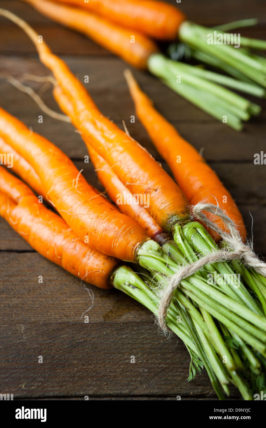 bundle of baby carrots on wooden boards, food close up Stock Photo - Alamy