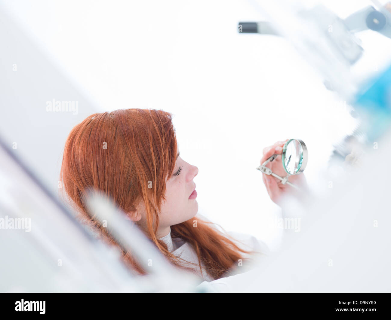 close-up of a girl student analyzing under a magnifier in a chemistry ...