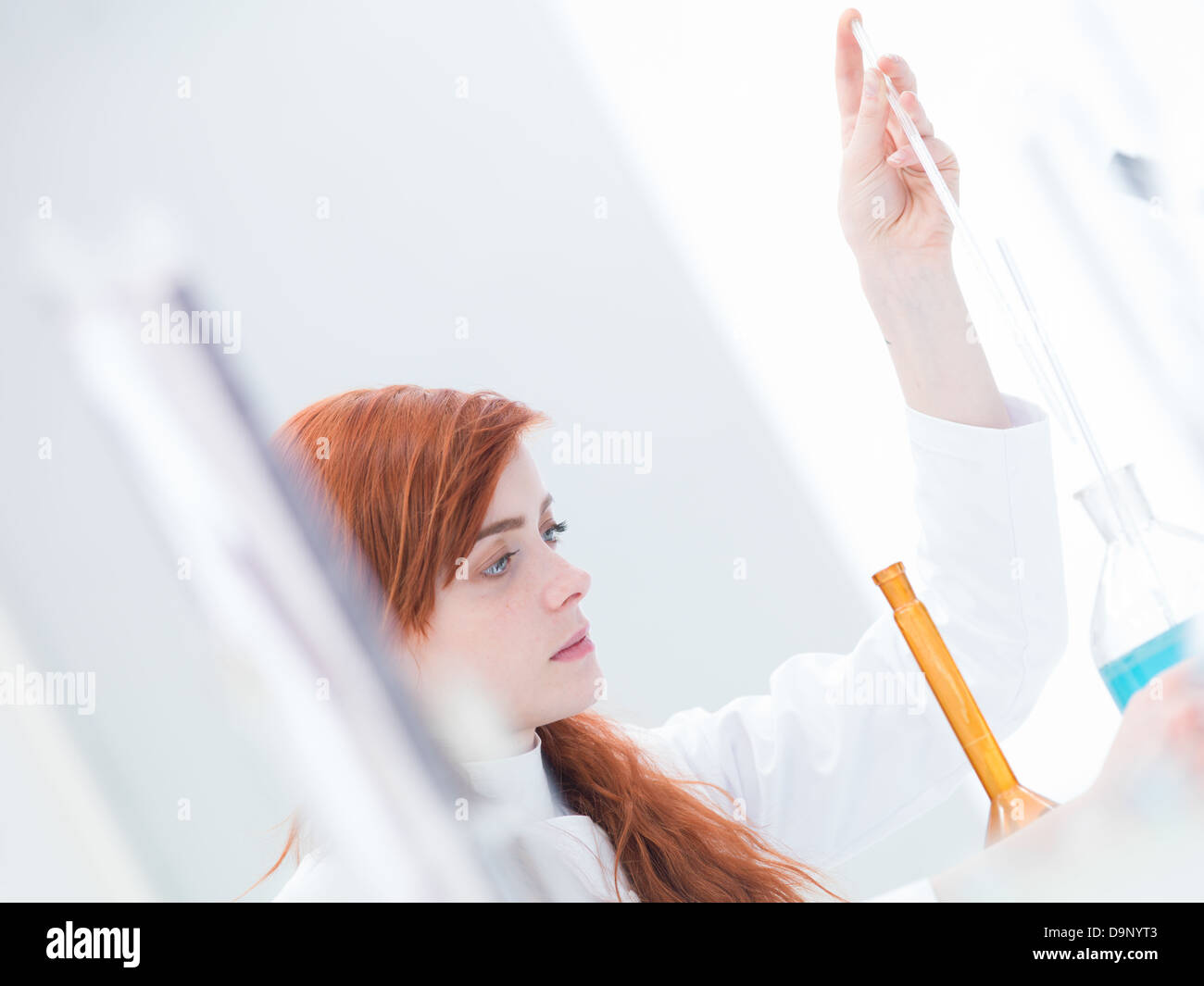 side-view of a beautiful girl student conducting an experiment in a ...