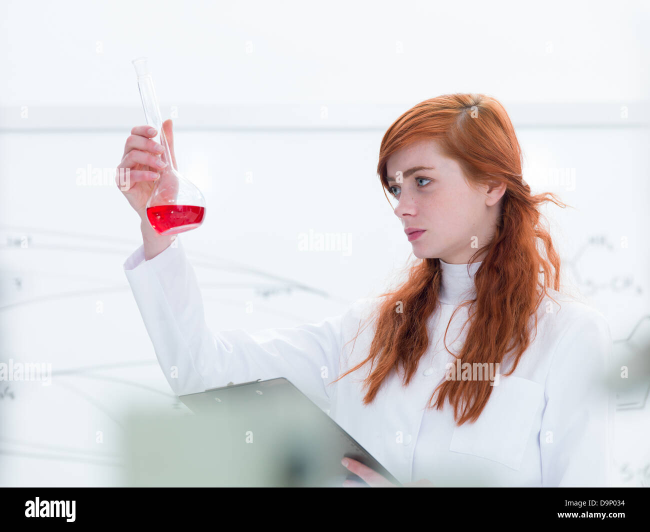 close-up of a beautiful girl student in a chemistry lab analyzing ...