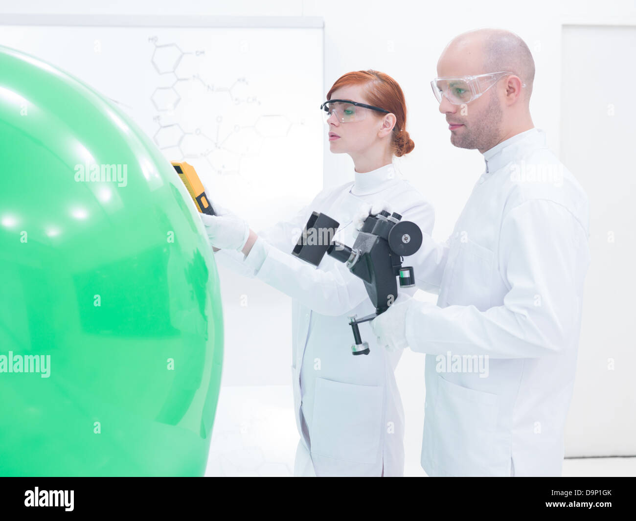 close-up of teacher and student in a chemistry lab scanning a green ...