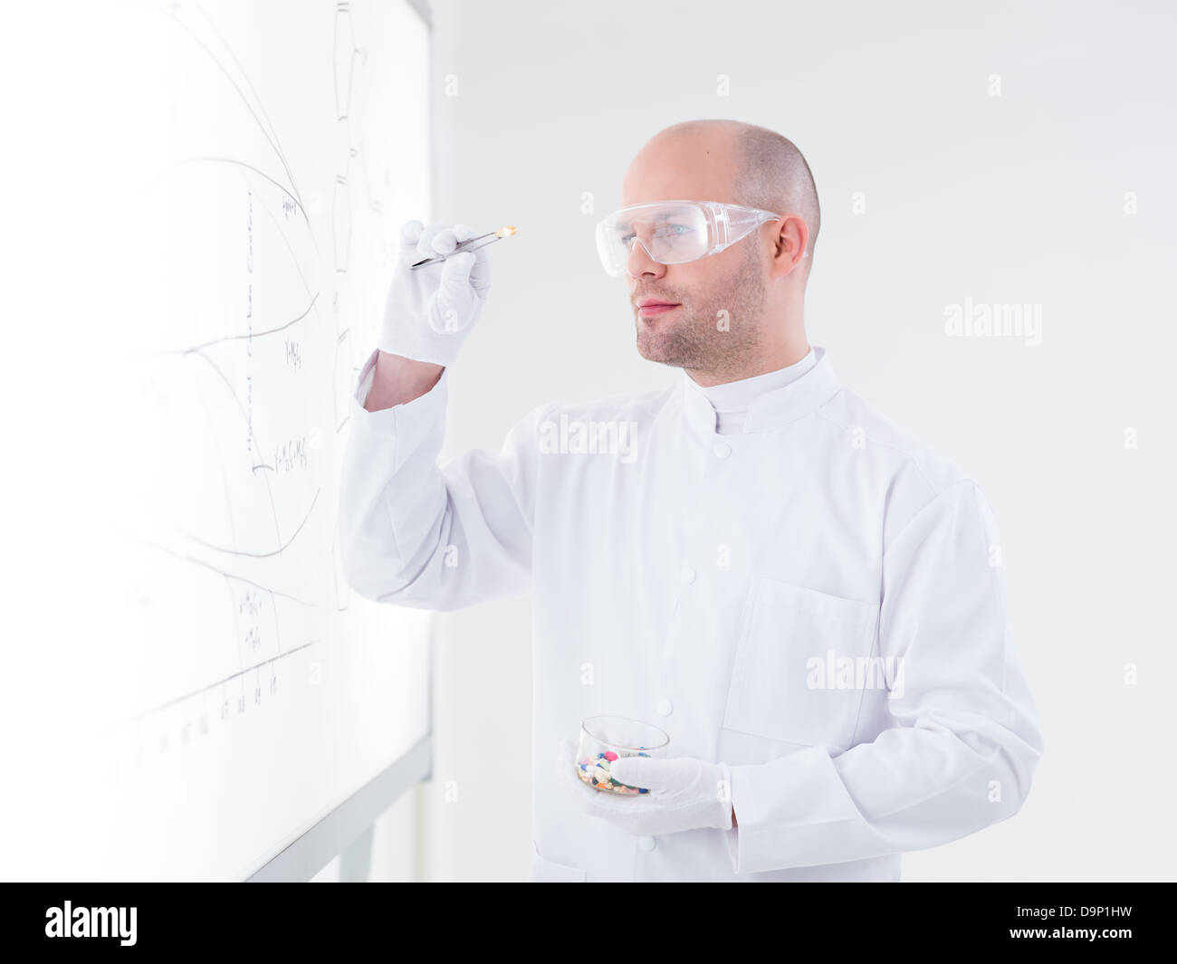 side-view of a scientist in a chemistry lab holding in his hands and ...