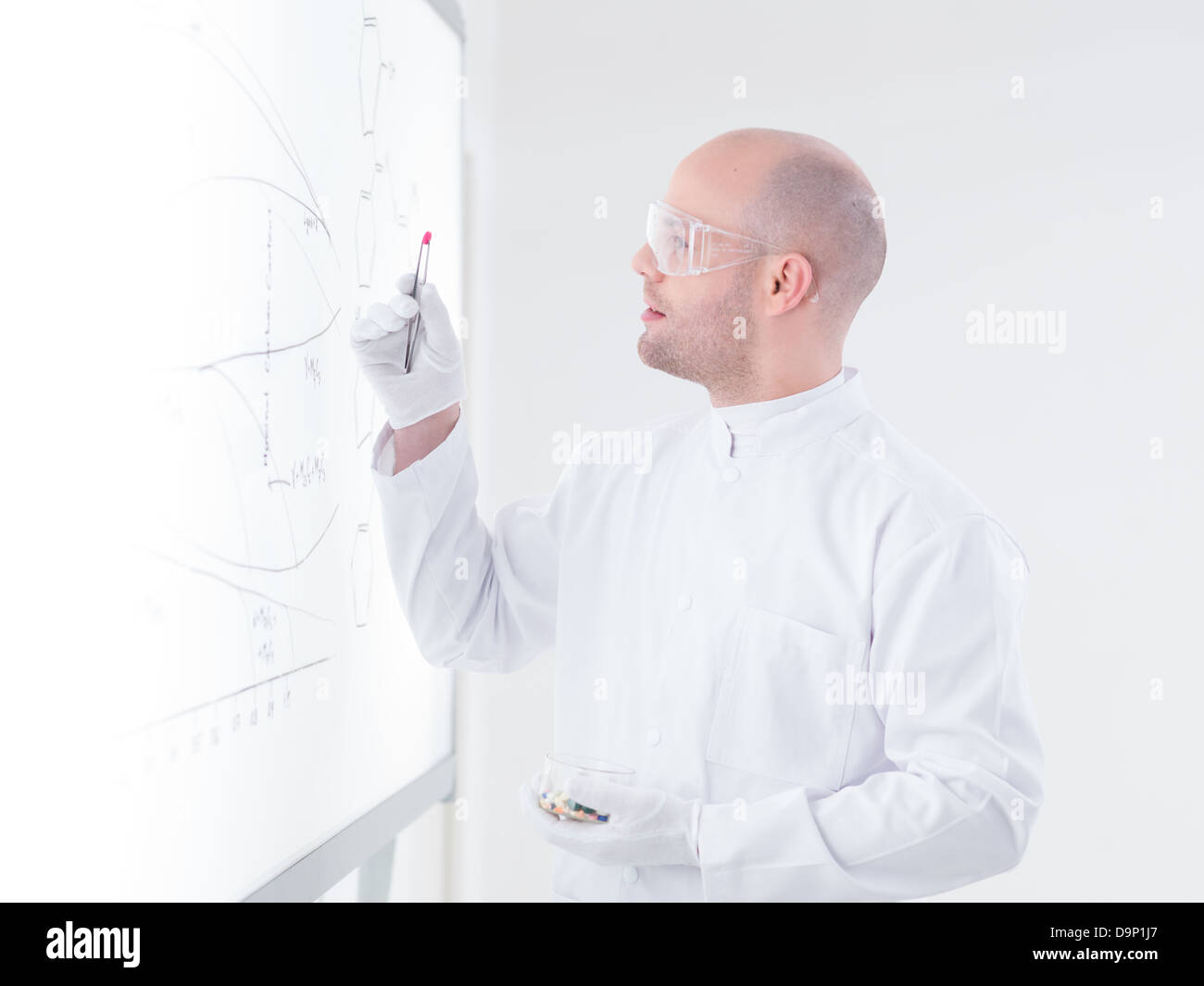 side-view of a scientist in a chemistry lab holding in his hands and ...
