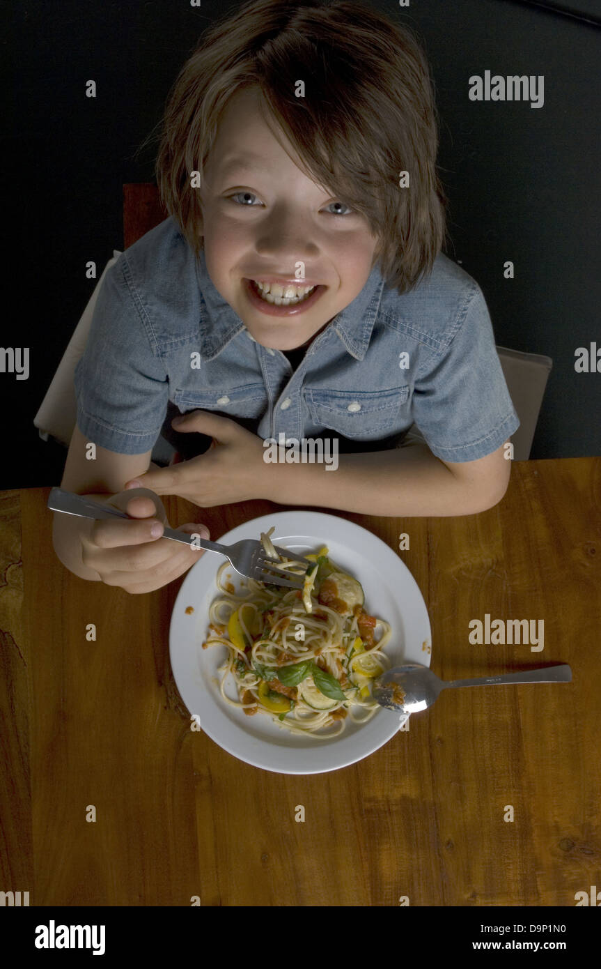 Boy eating pasta with vegetables Stock Photo - Alamy