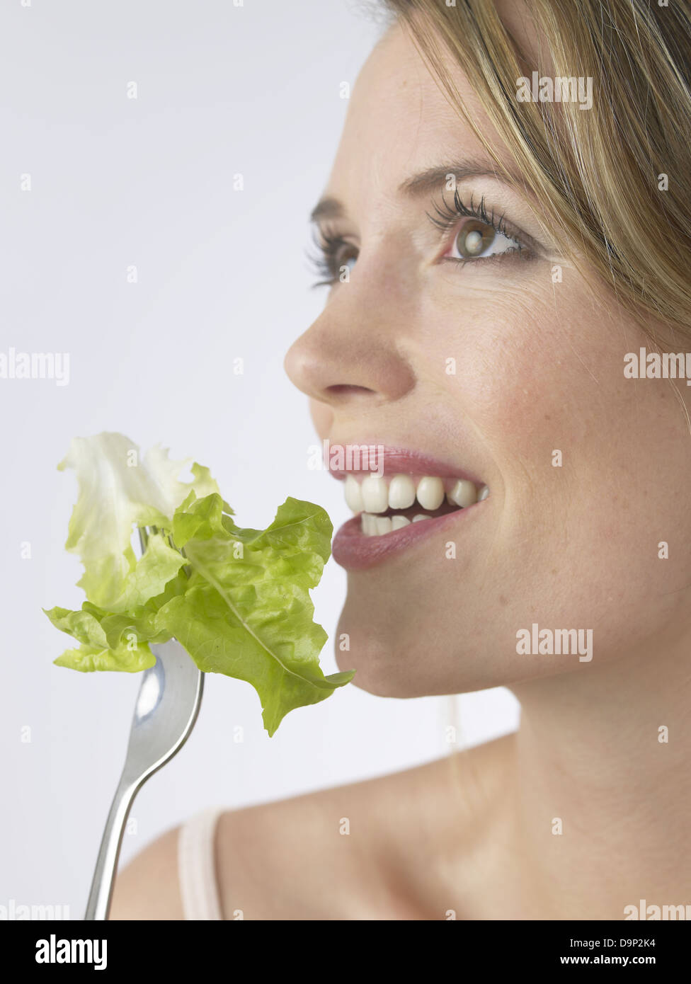 Woman eating lettuce leaf Stock Photo - Alamy