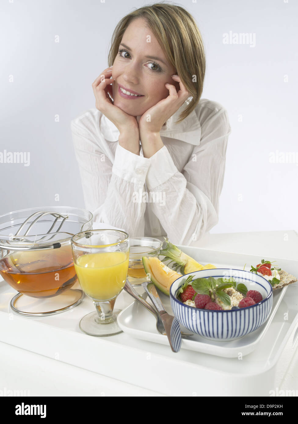 Woman sitting at breakfast table Stock Photo - Alamy