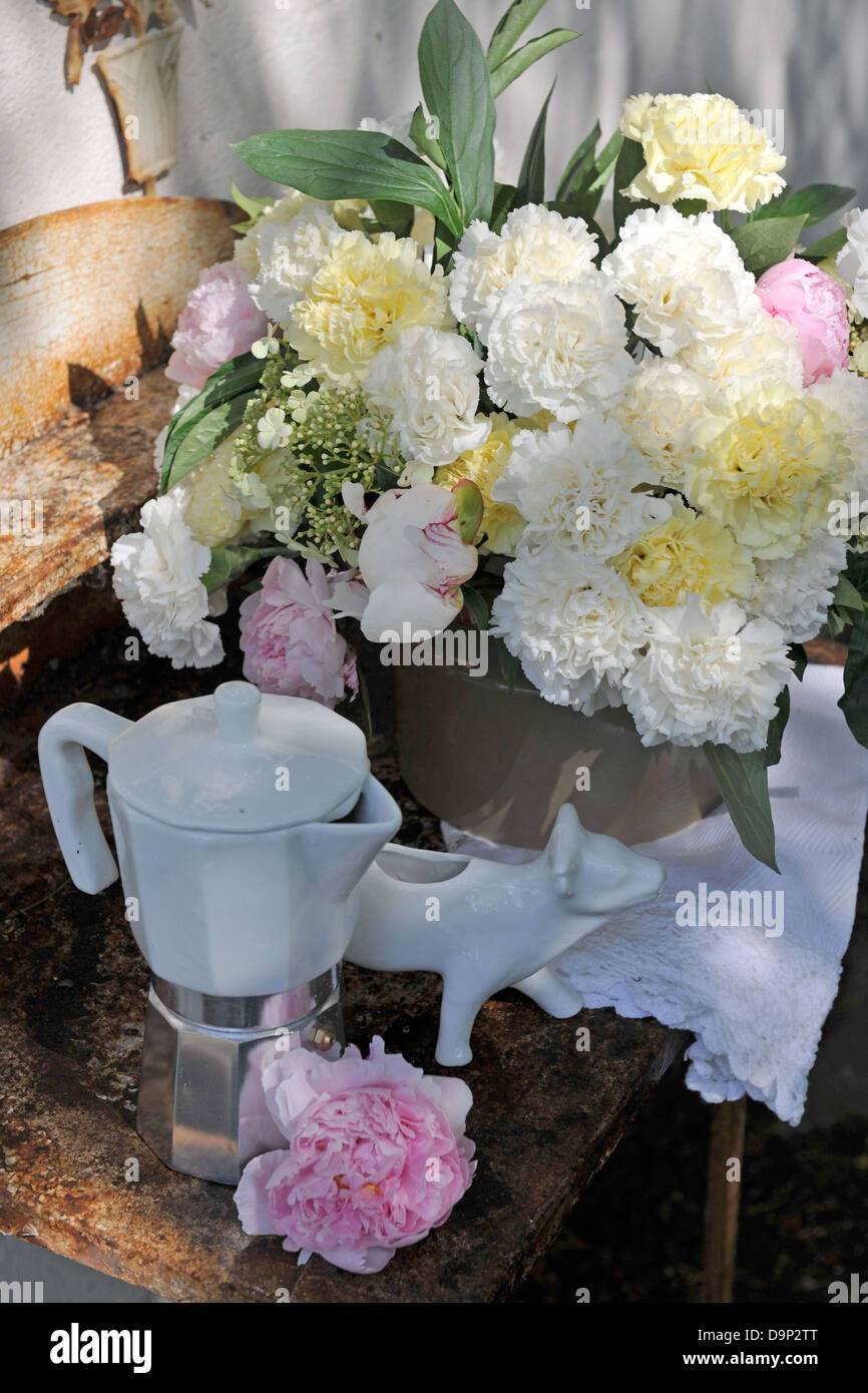 Bunch of flowers, animal figurine and coffee pot outdoors Stock Photo ...