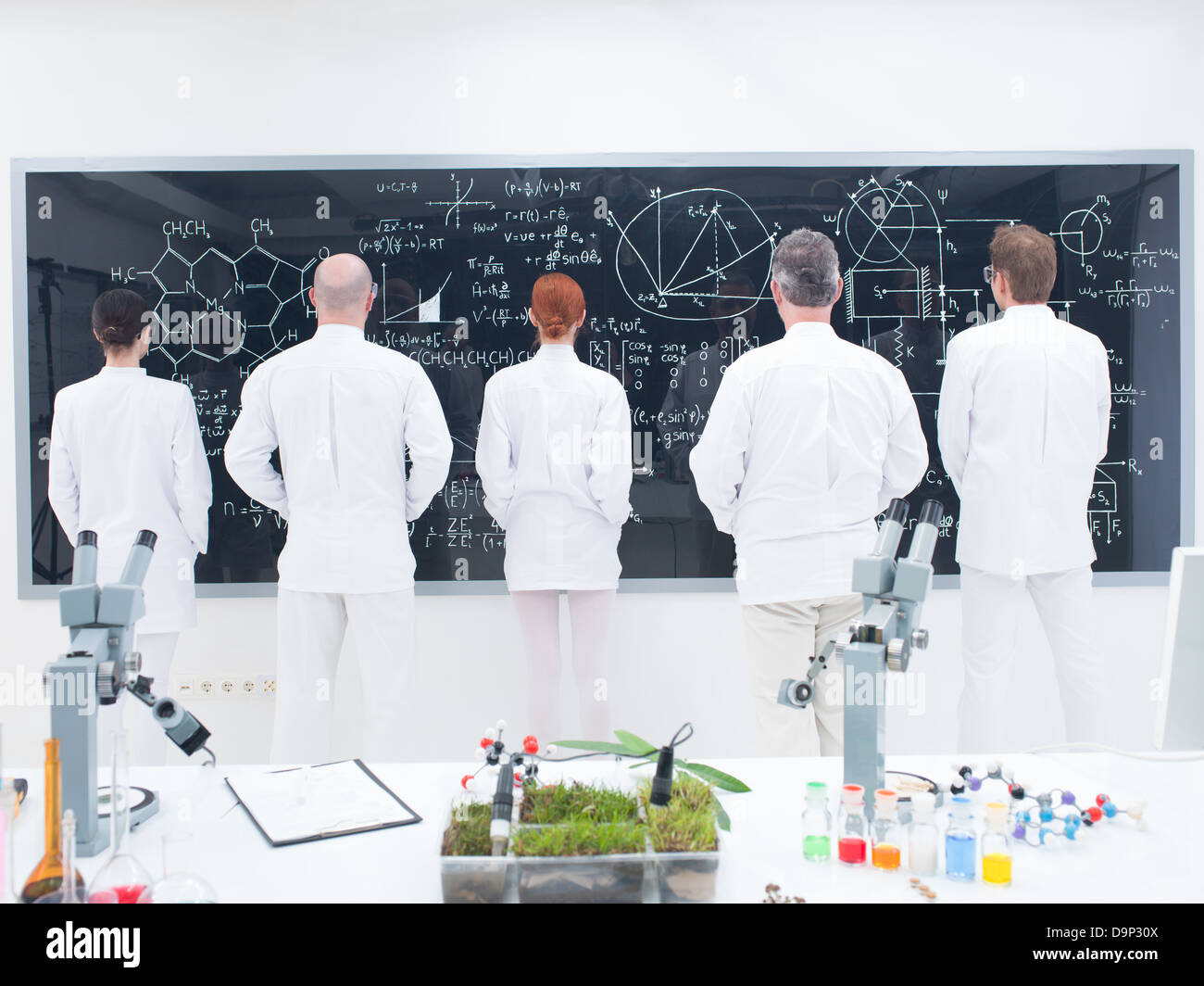 general-view of five scientists in a chemistry lab in front of a ...