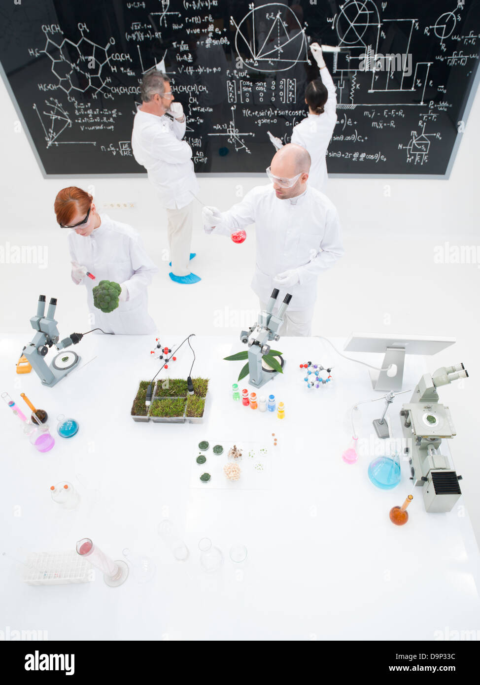 bird-eye of four people in a chemistry lab conducting experiments ...