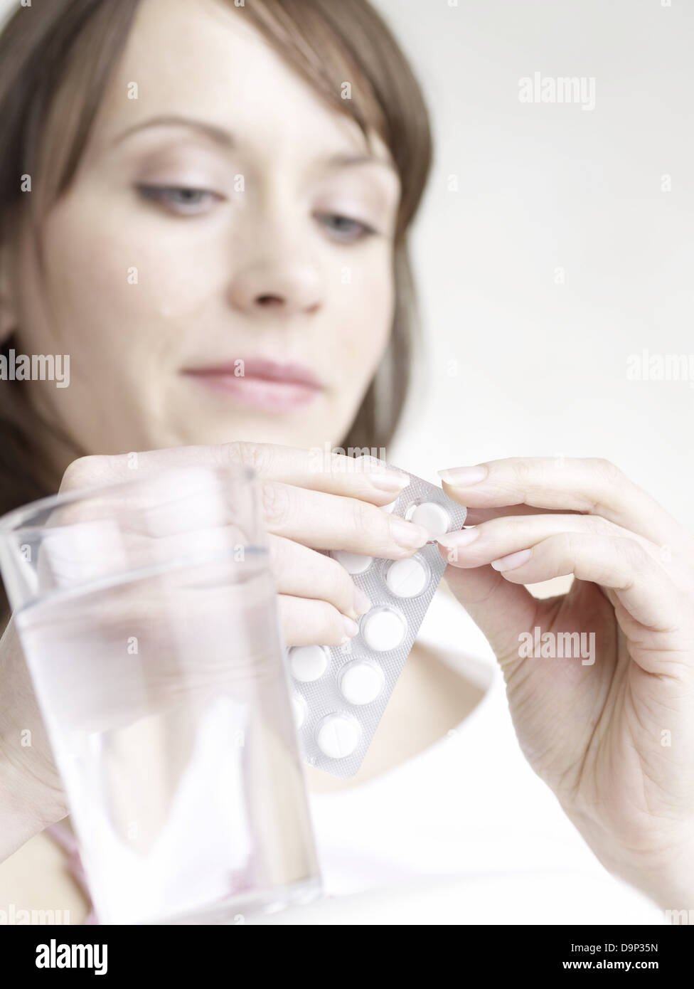 Woman taking tablets Stock Photo - Alamy