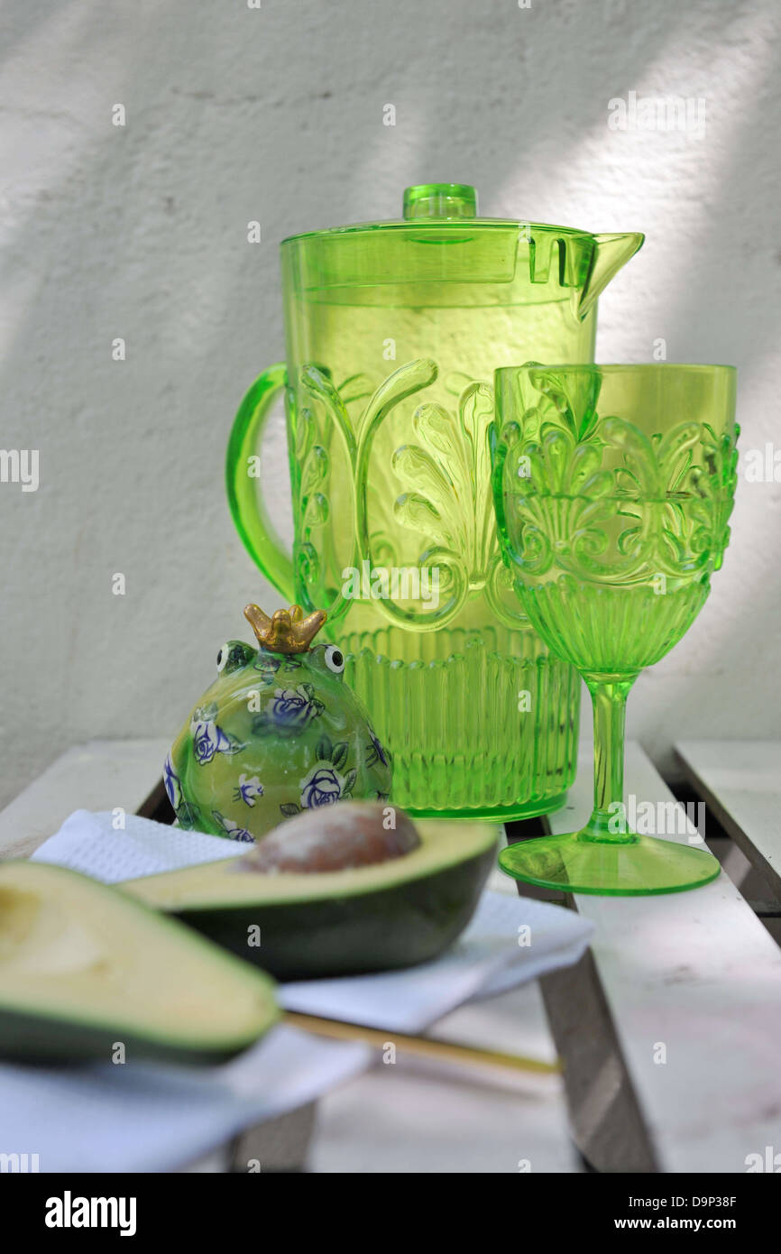 Avocado, frog figurine, green pitcher and glass Stock Photo - Alamy