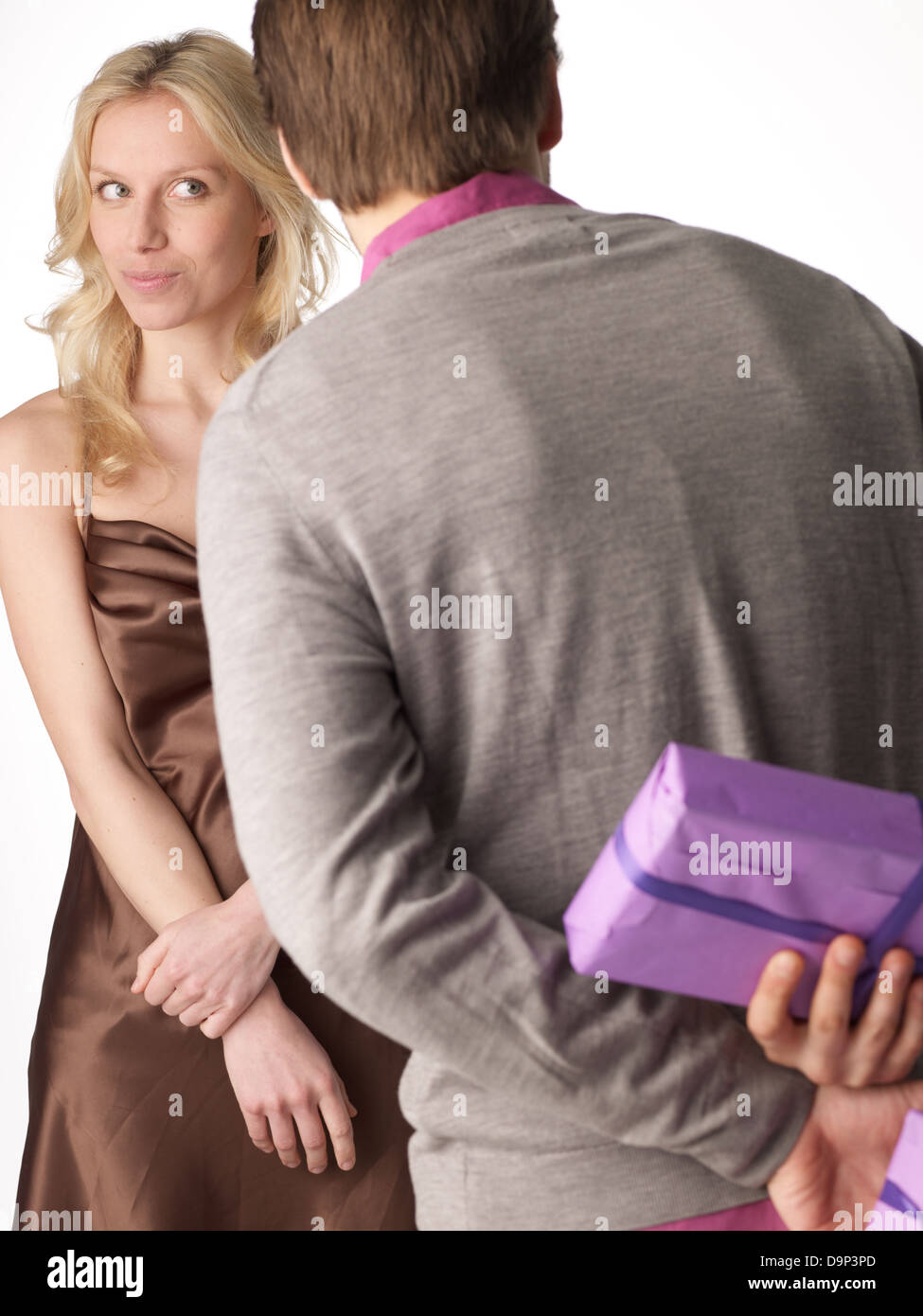 Man holding gift behind her back Stock Photo - Alamy