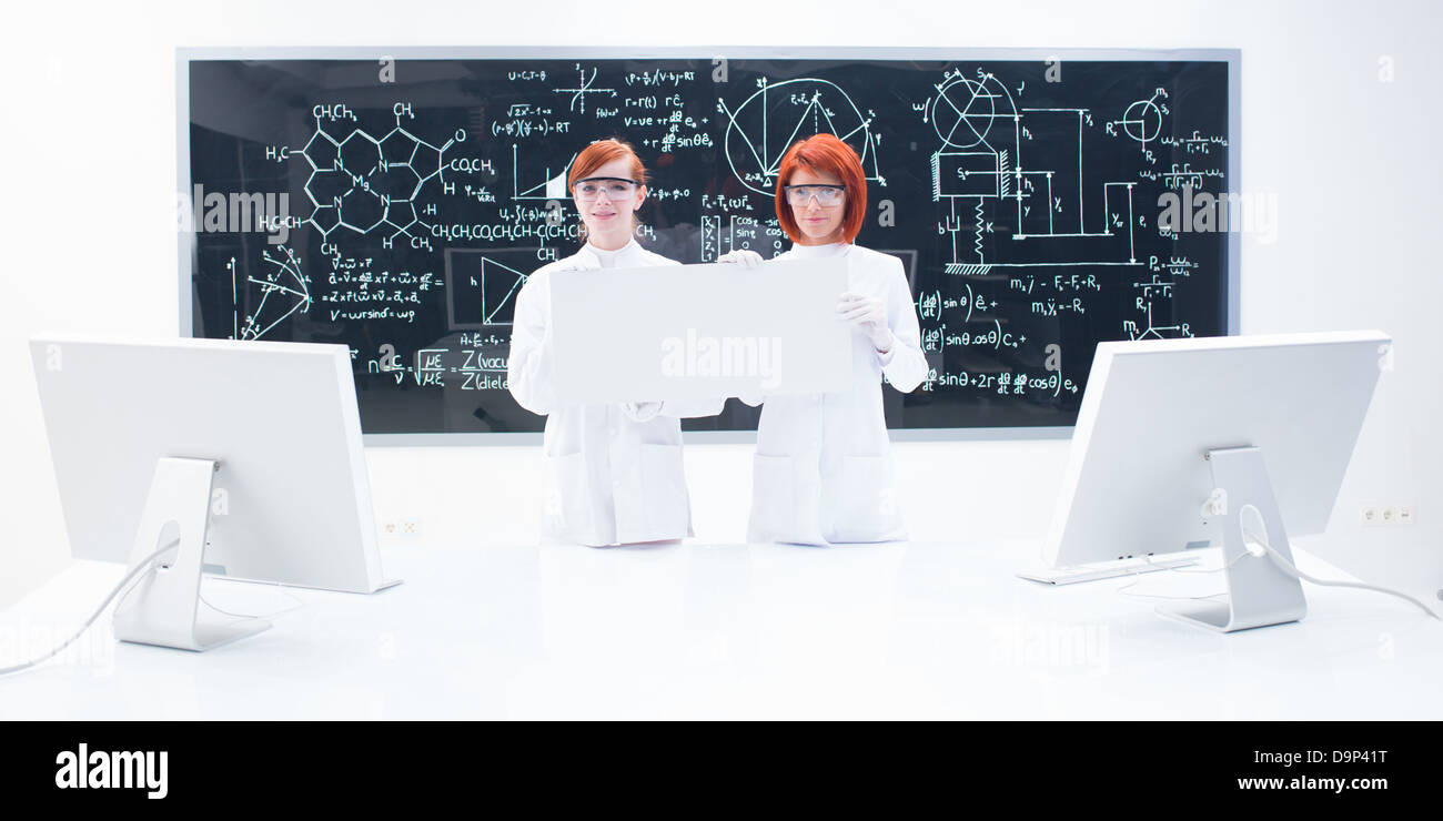 general-view of two students in a chemistry lab around a lab table with ...