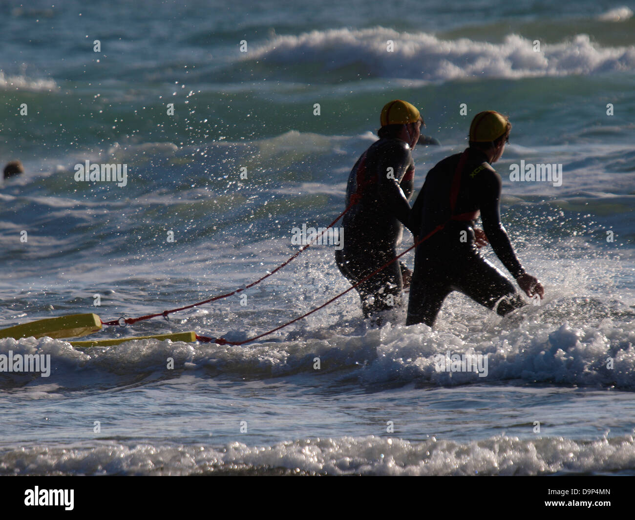 Two surf life savers heading into the sea during a training session ...