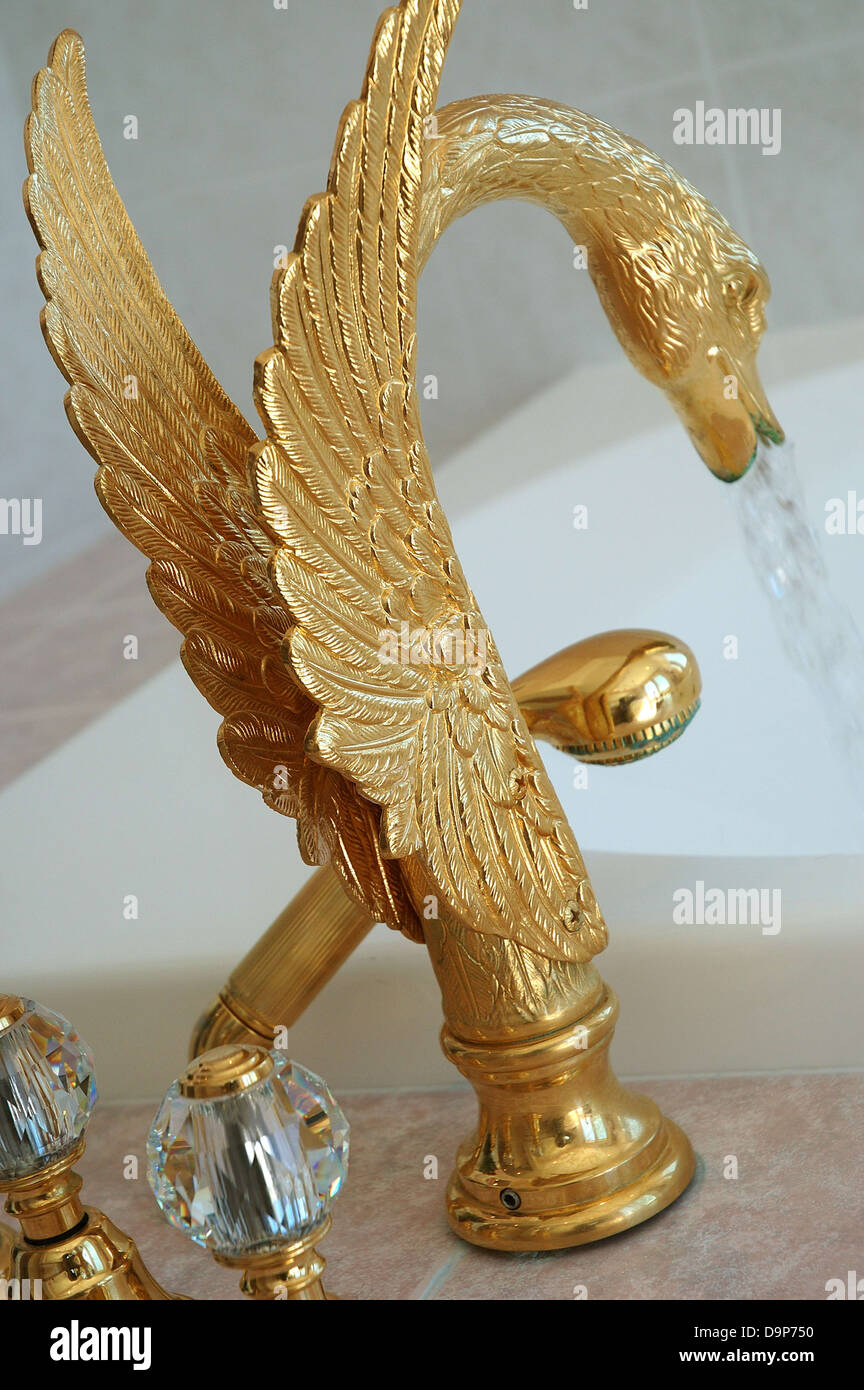 Tap in bath in shape of a golden swan Stock Photo - Alamy