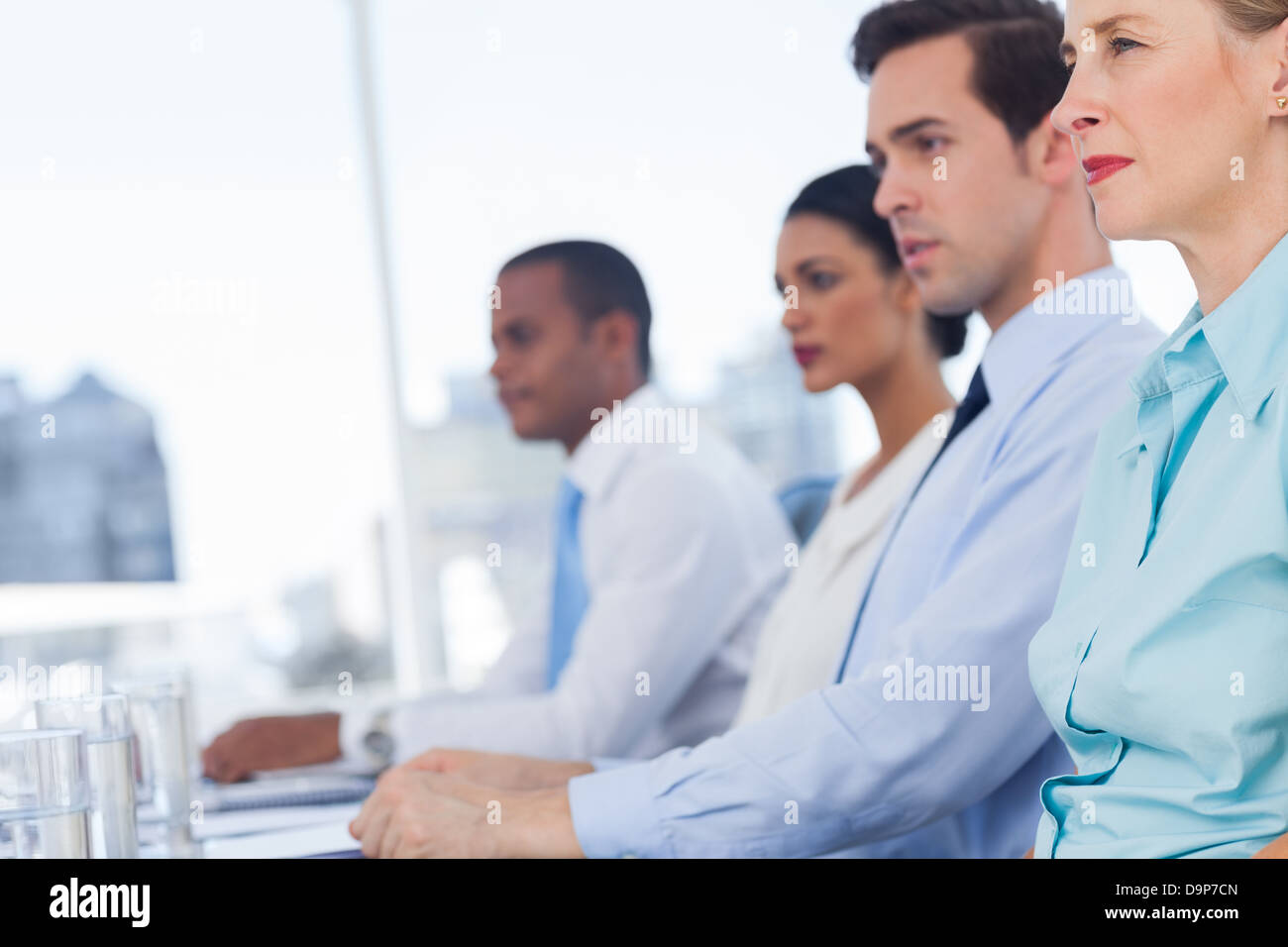 Serious business people sitting in line Stock Photo - Alamy