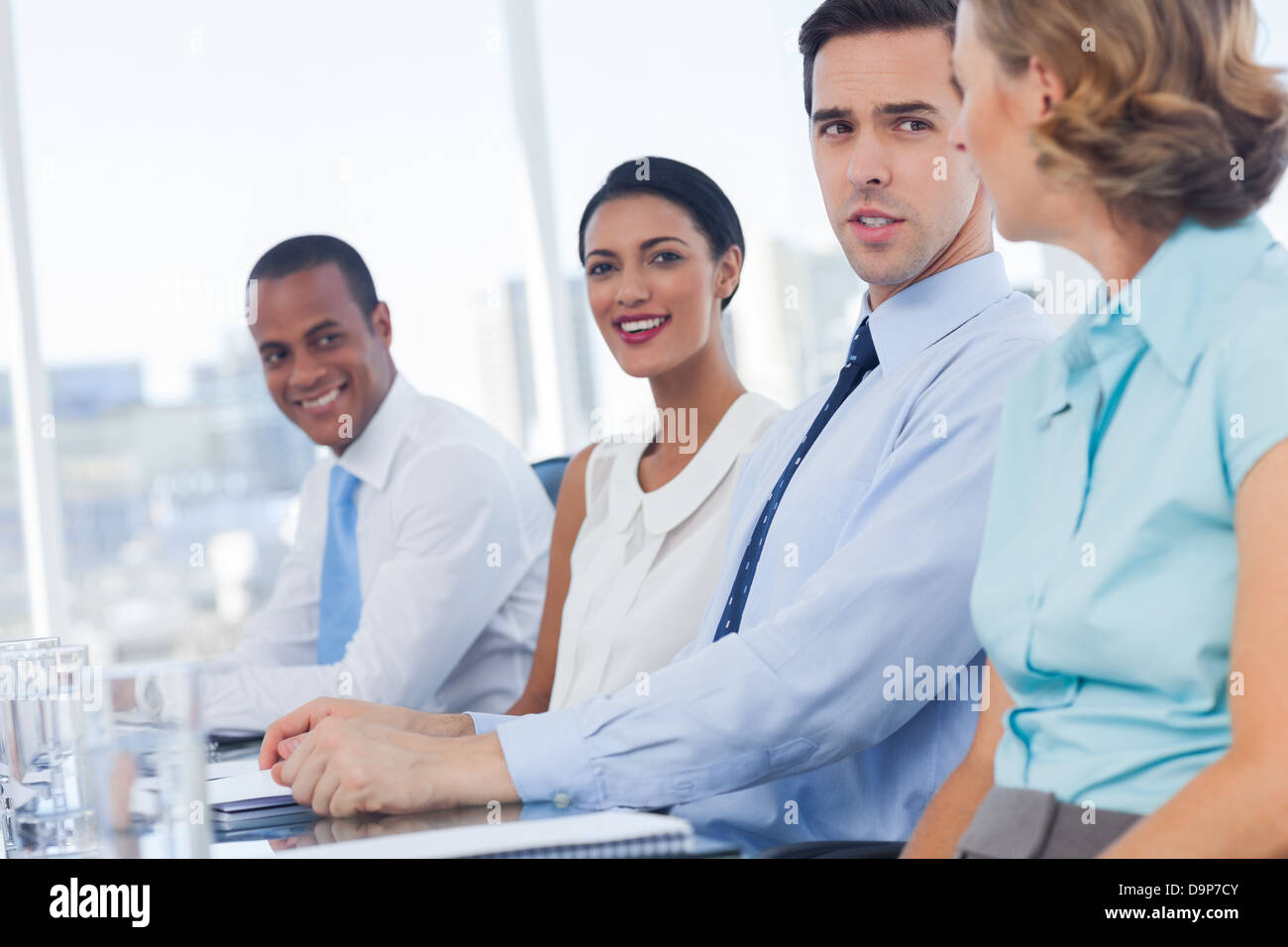Smiling business people sitting in line Stock Photo - Alamy