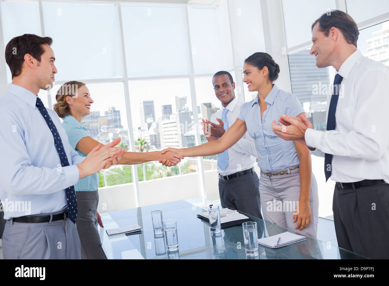 Business people clapping their hands between colleagues Stock Photo - Alamy