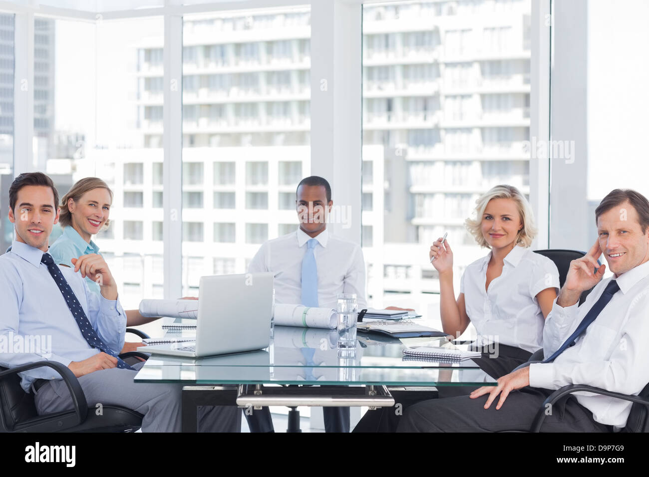 Business people looking at camera during a meeting Stock Photo - Alamy