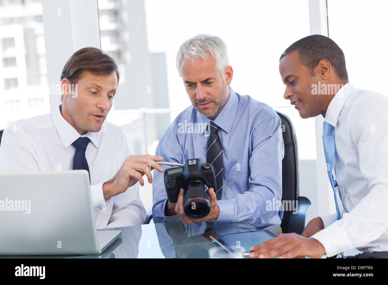 Three business men watching a camera Stock Photo - Alamy