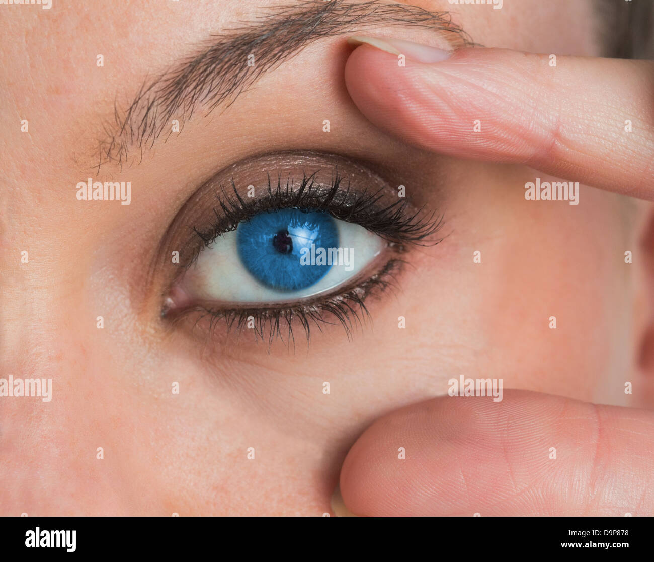 Woman stretching her eye Stock Photo - Alamy