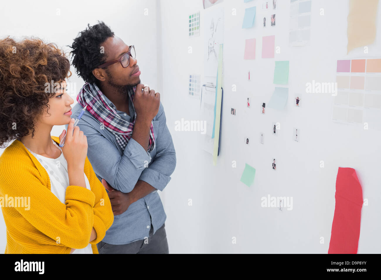 Thoughtful designers standing in front of material samples Stock Photo ...
