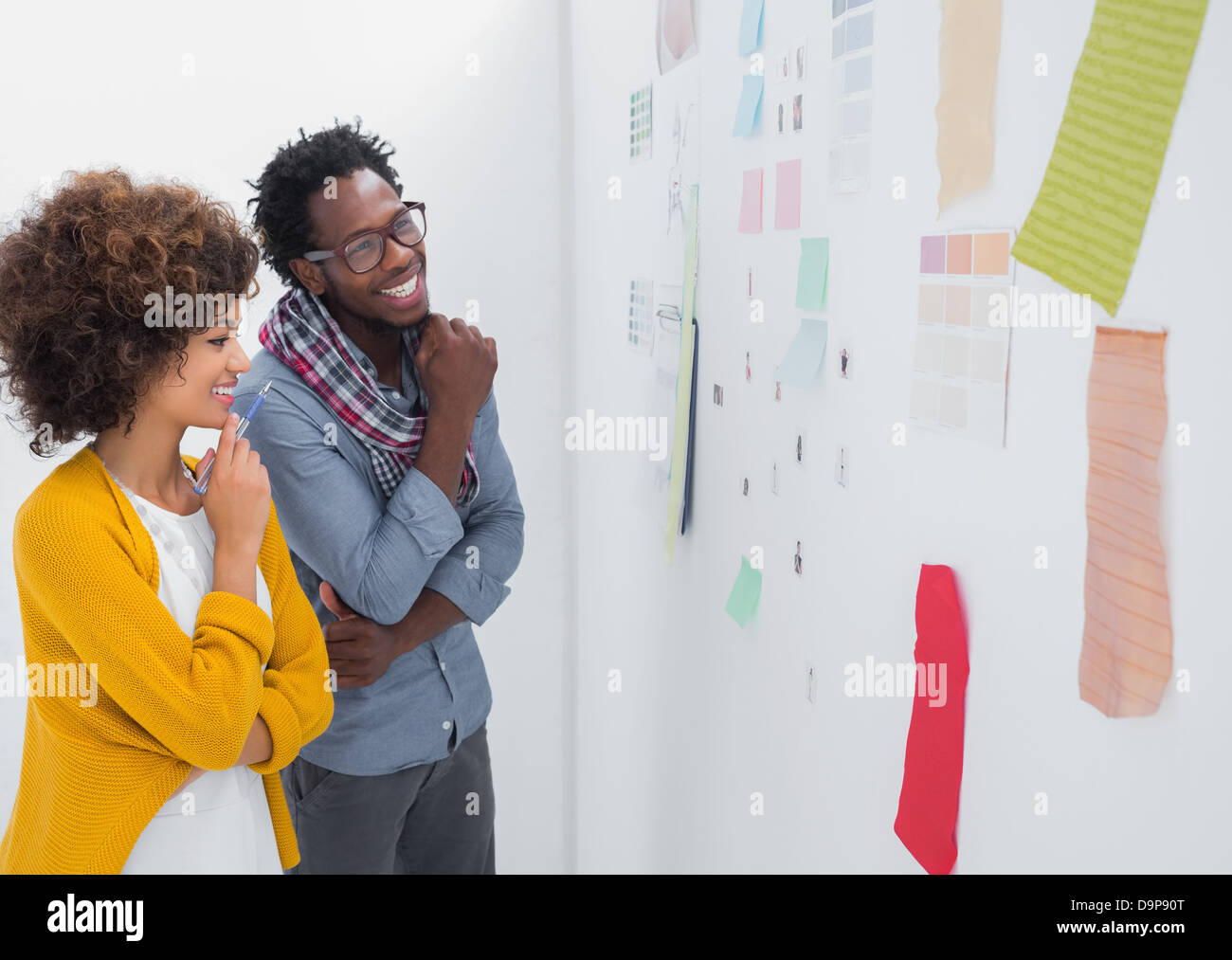 Cheerful designers standing in front of material samples Stock Photo ...