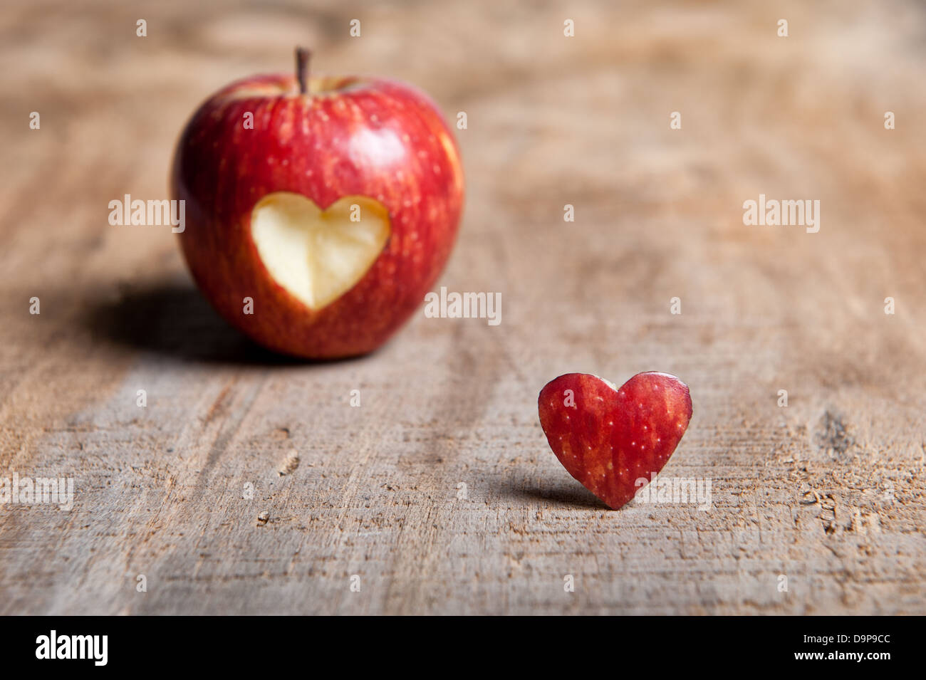 Red apple with heart-shape cut out. The cut-out heart is placed in ...
