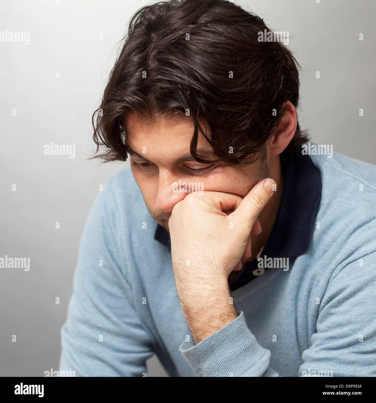 A brunette man with longer hair in blue pullover being depressed Stock ...