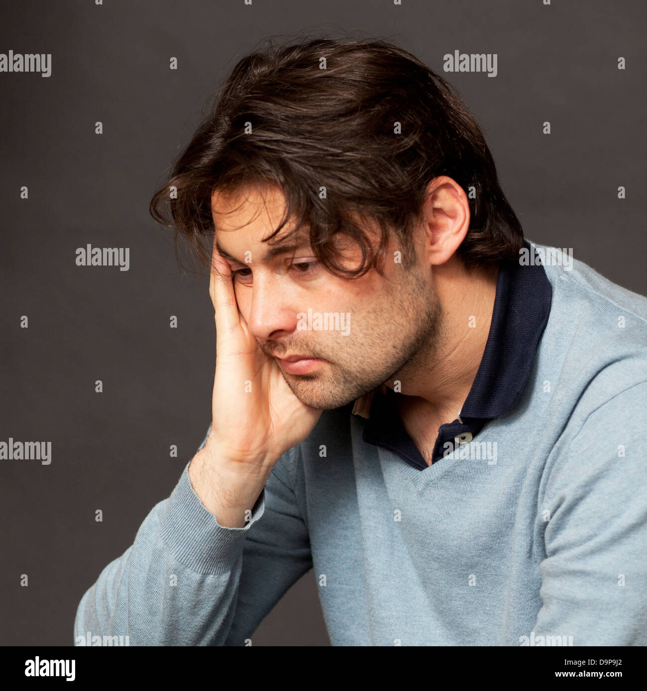 A brunette man with longer hair in blue pullover being depressed Stock ...