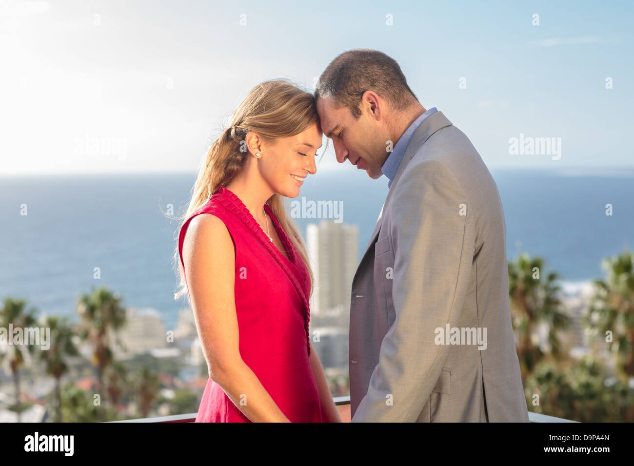 Couple holding hands on balcony Stock Photo - Alamy