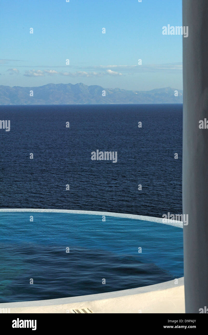 Infinity pool at the ocean with mountains in background Stock Photo - Alamy