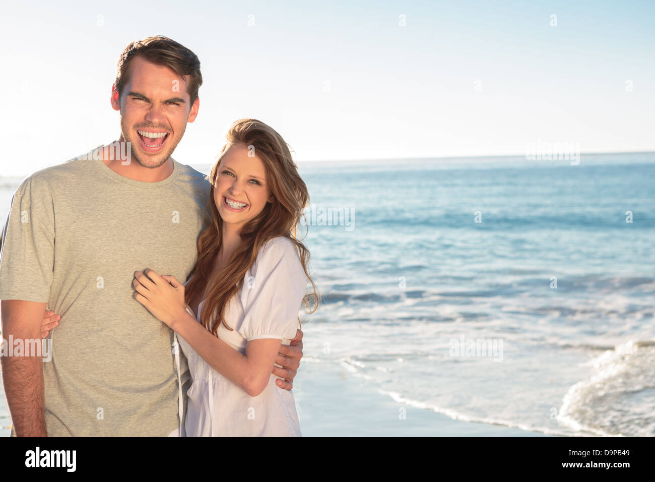 Pretty couple standing and embracing on the beach Stock Photo - Alamy