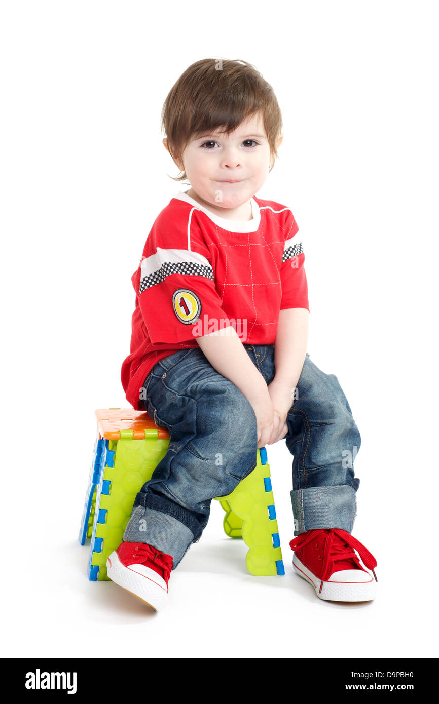 Toddler baby sitting on a seat on white background Stock Photo - Alamy