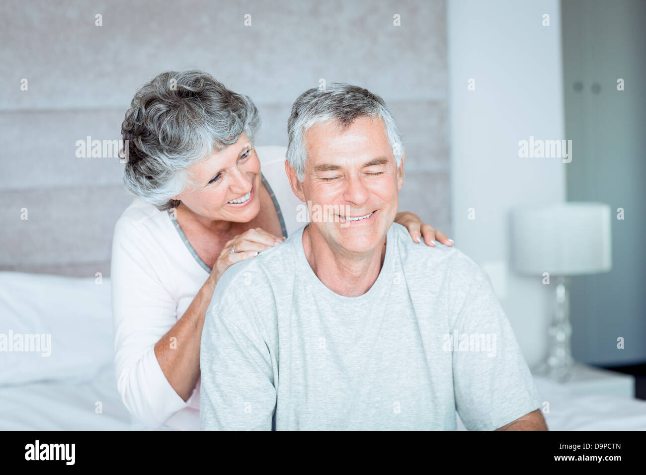 Mature woman giving a massage to her husband Stock Photo - Alamy
