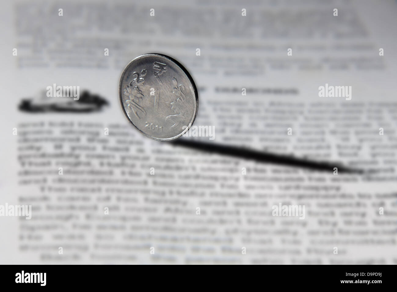 Close-up of a one rupee coin on an open book Stock Photo - Alamy