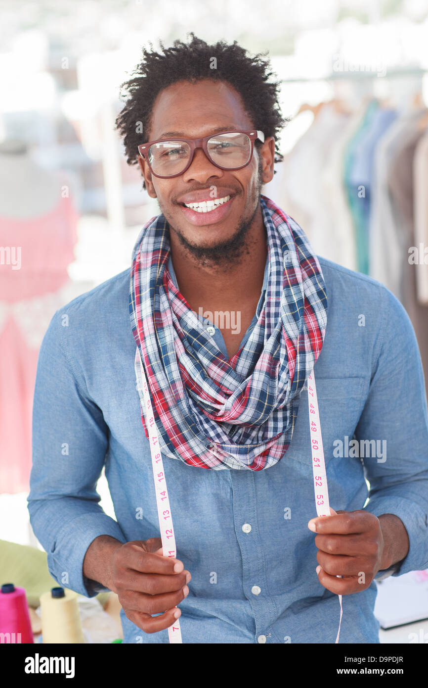 Fashion designer standing with a measuring tape Stock Photo - Alamy