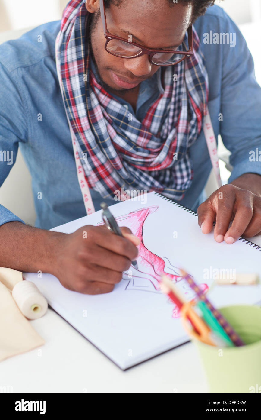 Concentrated artistic man drawing clothes Stock Photo - Alamy