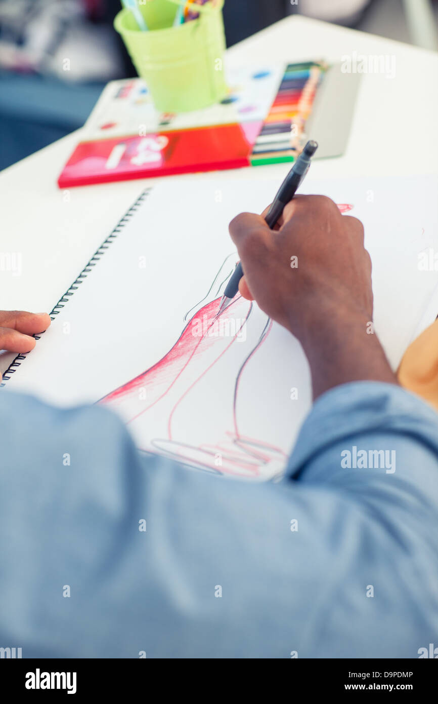 Artistic man drawing clothes in a studio Stock Photo - Alamy