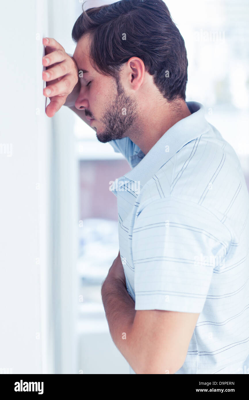 Stressed man leaning against a wall Stock Photo - Alamy