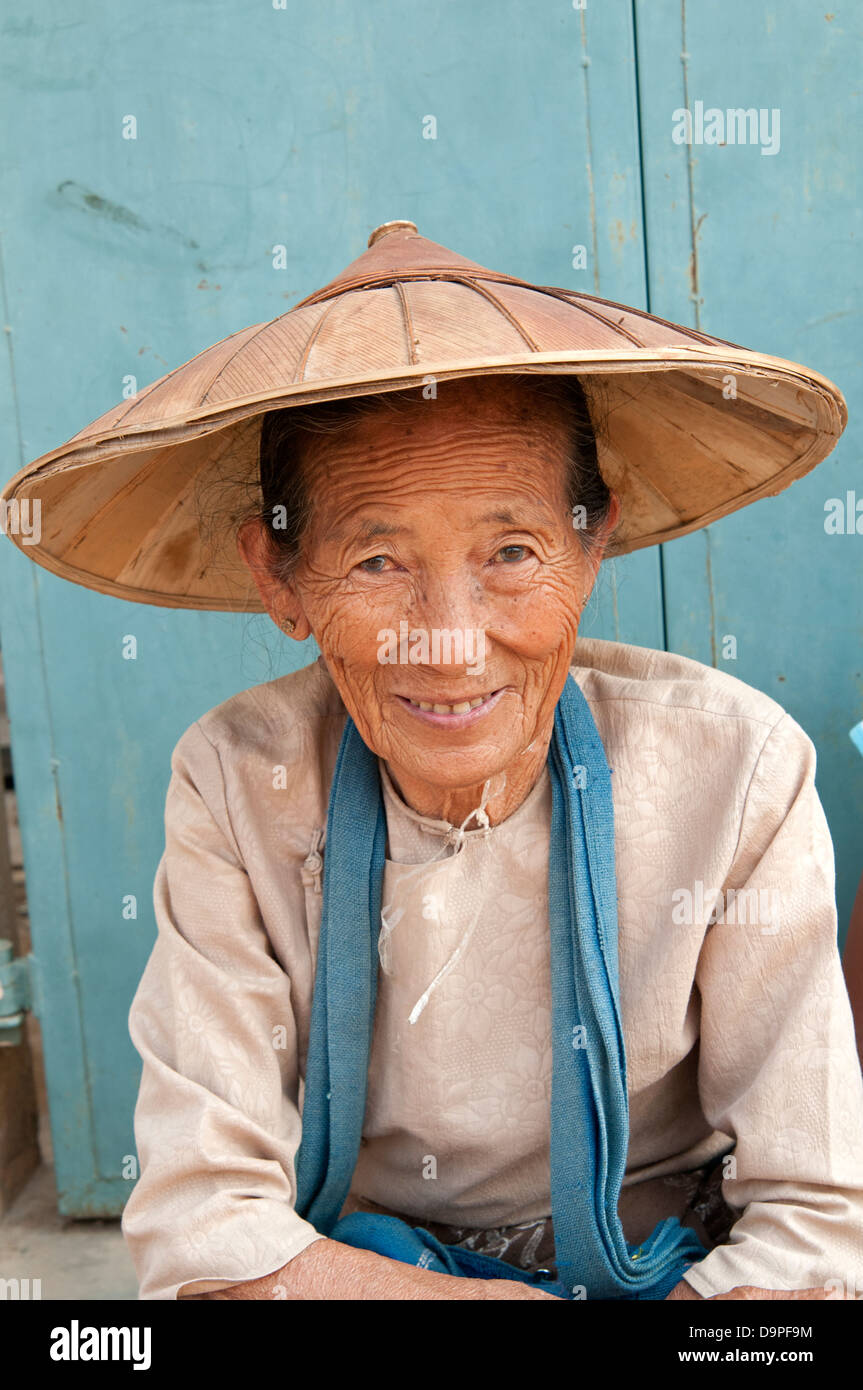 Old Burmese smiling woman wearing traditional Shan states hat sitting ...