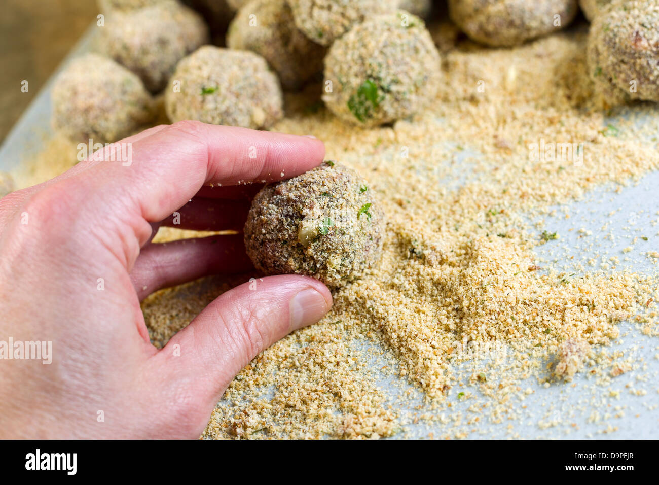Hand holding bread coated raw meatball hi-res stock photography and ...