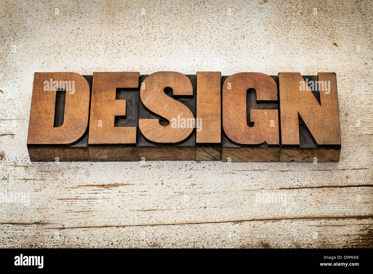 design word in vintage letterpress wood type on a grunge painted barn ...