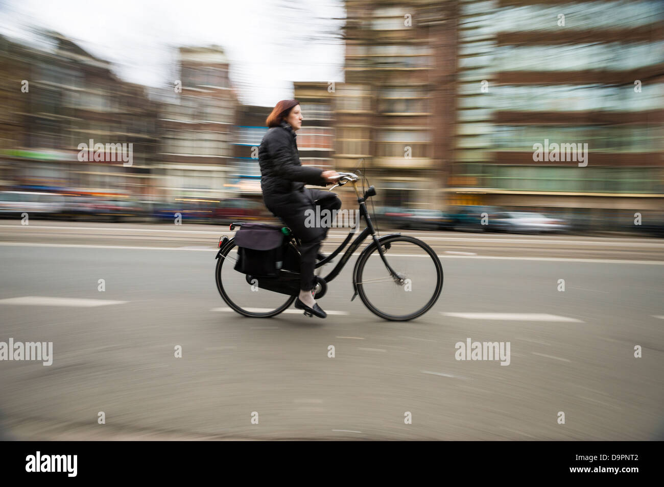 WOMAN RIDING BICYCLE IN AMSTERDAM Stock Photo - Alamy