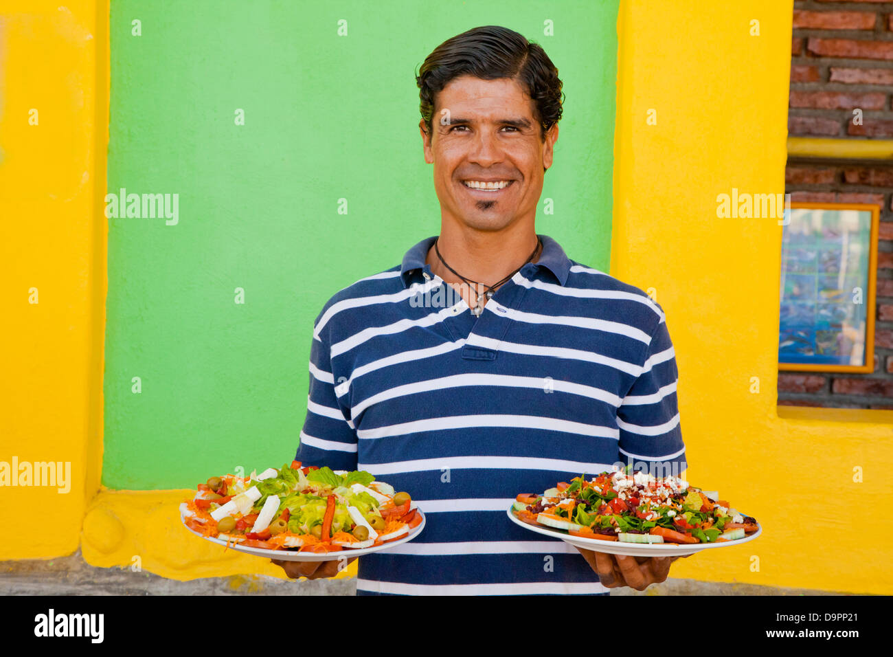 Man holding plates of mexican food Stock Photo - Alamy