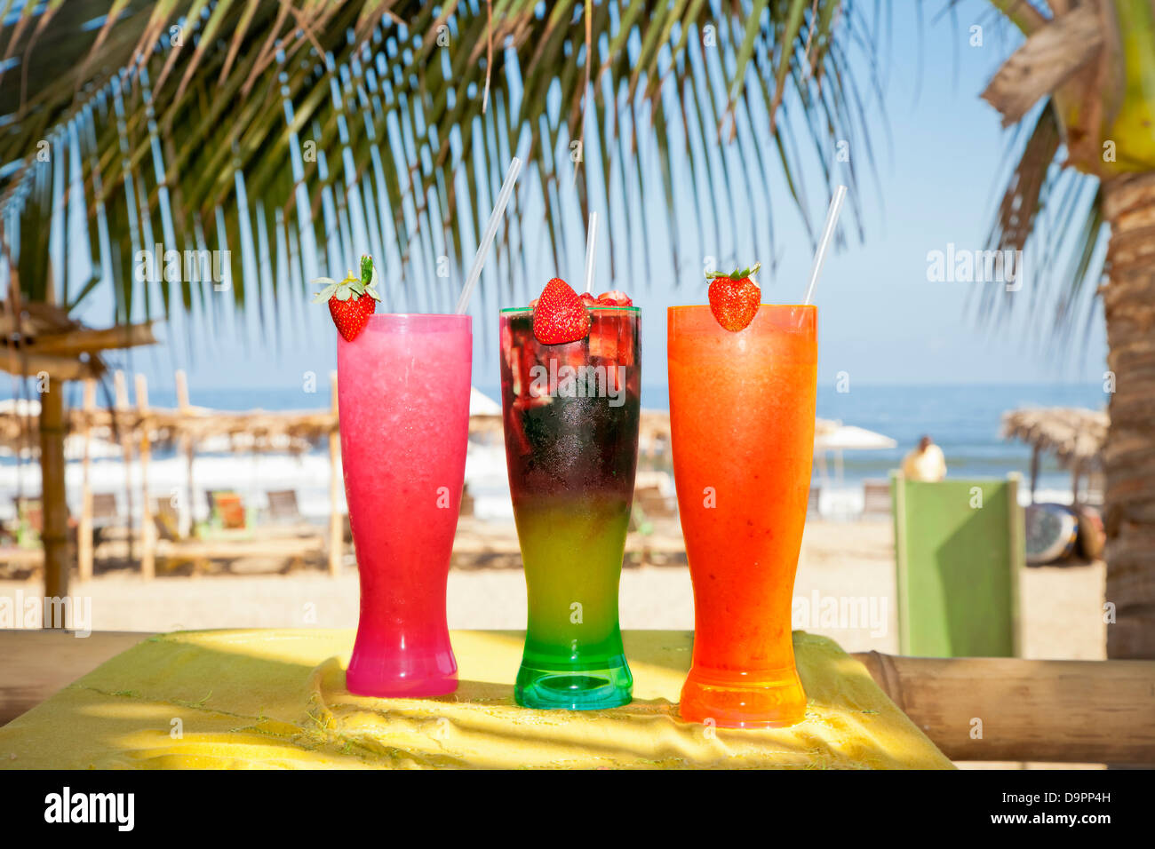Row of colorful drinks on seaside table Stock Photo - Alamy