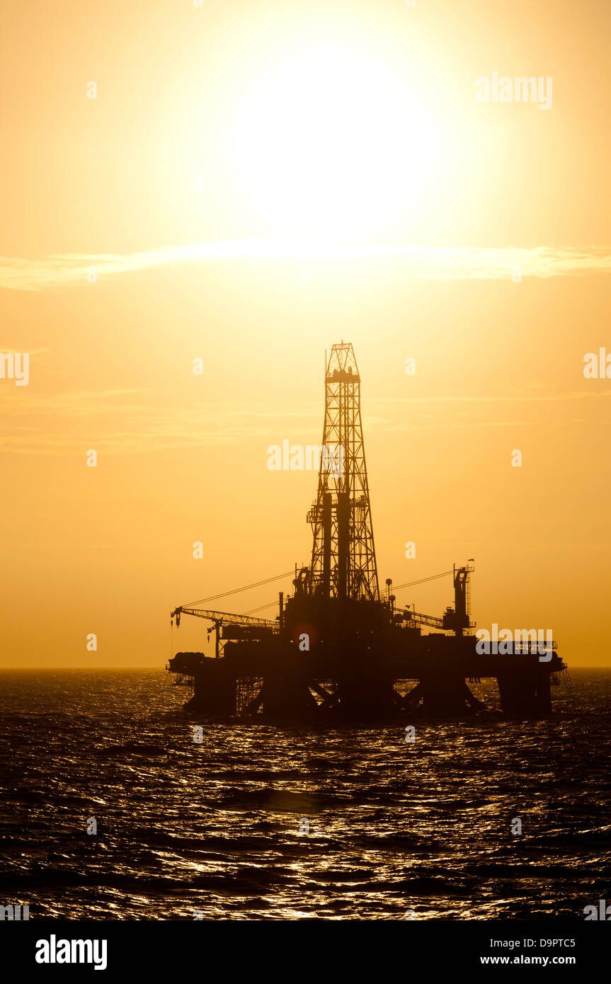 Silhouette of an offshore floating oil drilling rig. Deep sea at sunset ...