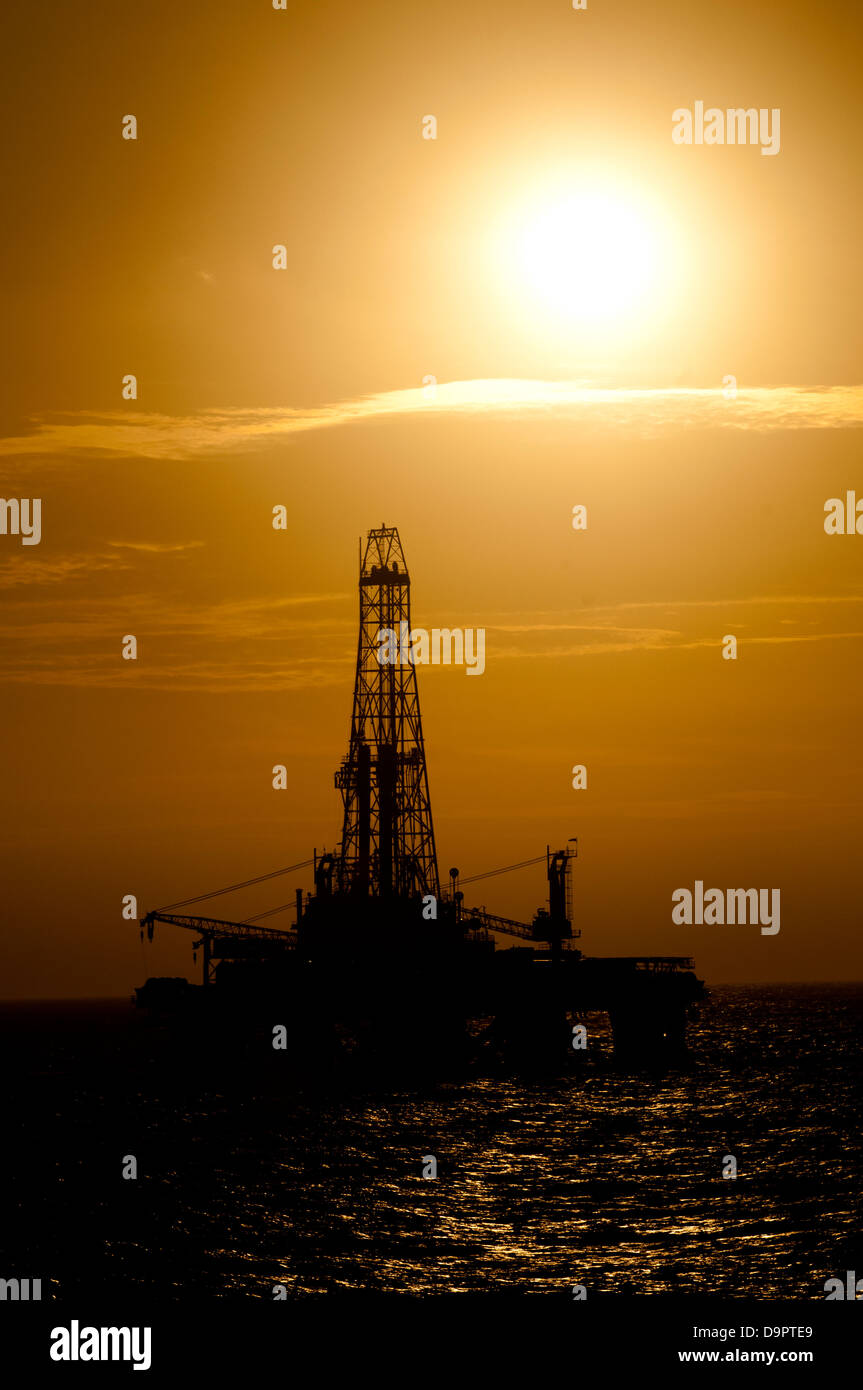 Silhouette of an offshore floating oil drilling rig. Deep sea at sunset ...