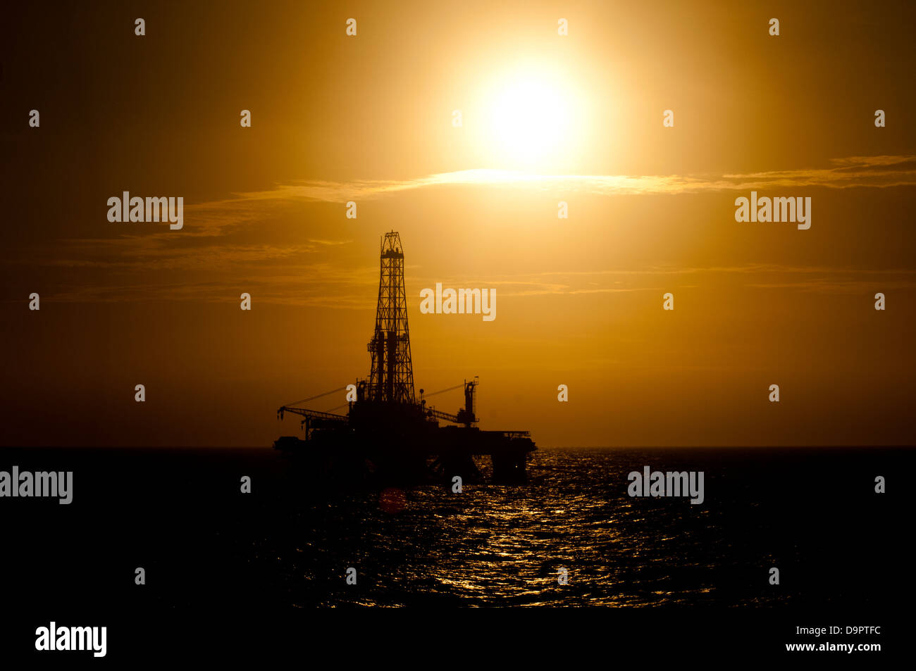Silhouette of an offshore floating oil drilling rig. Deep sea at sunset ...