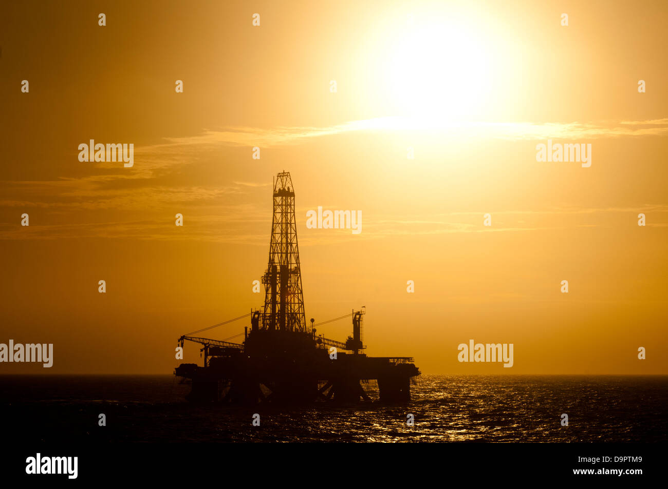 Silhouette of an offshore floating oil drilling rig. Deep sea at sunset ...
